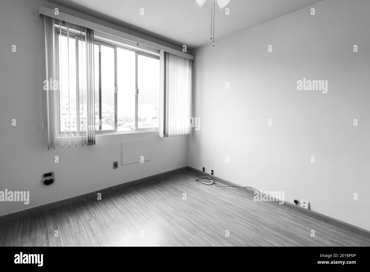 An empty apartment room interior with blank white walls and sliding ...