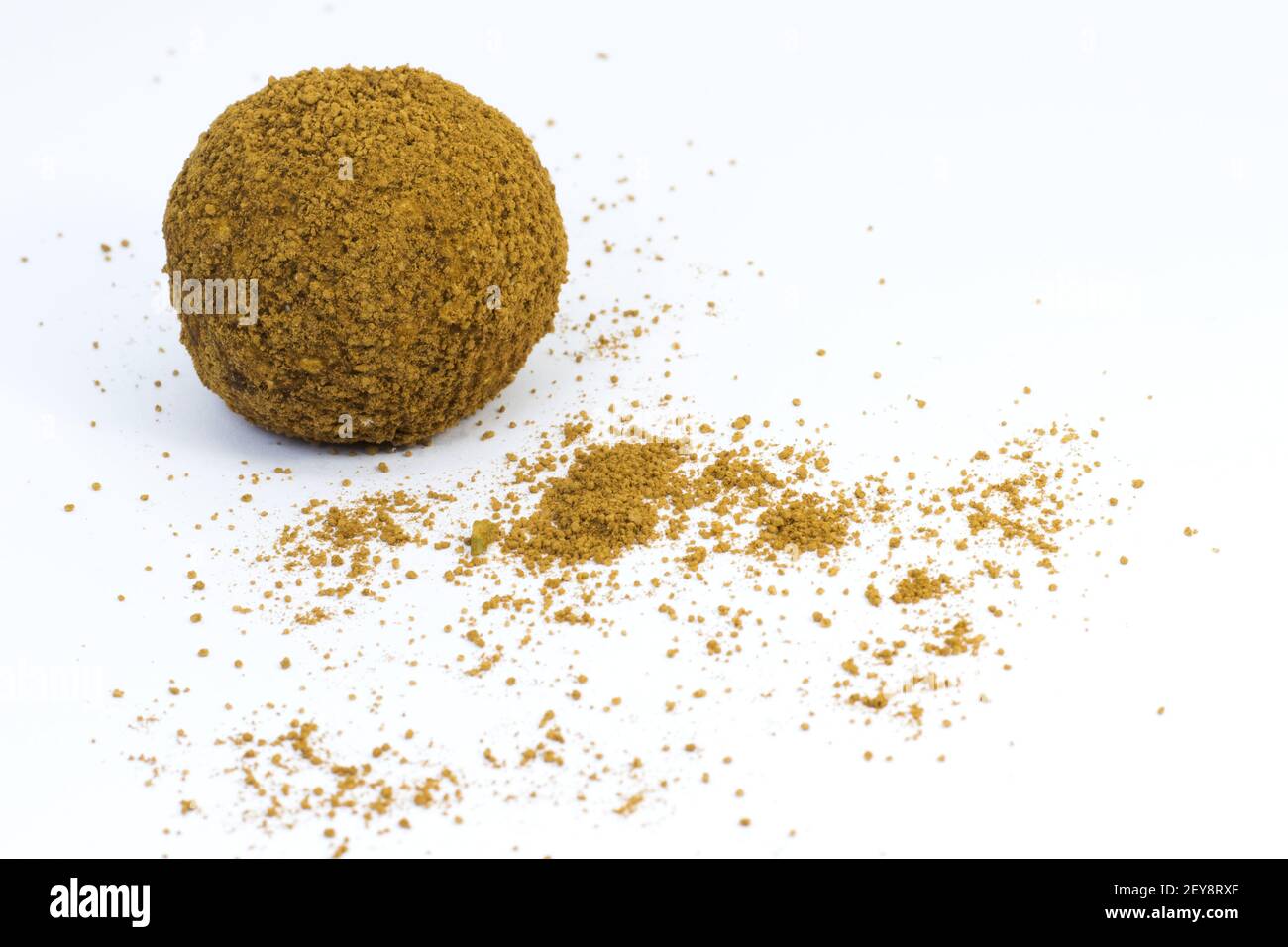 A chocolate truffle ball with powder on a white surface Stock Photo - Alamy