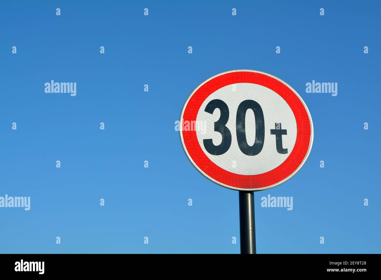 Red and white 30 ton sign against a plain blue sky Stock Photo - Alamy