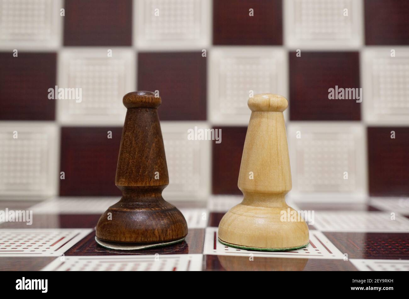 A close-up shot of black and white wooden Bishops on the chess board ...