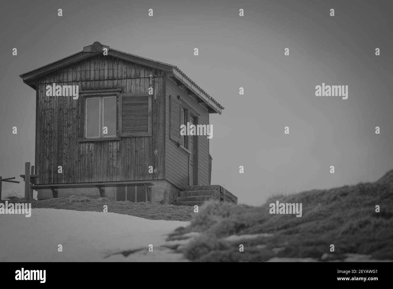 A grayscale shot of a small wooden house in the village Stock Photo - Alamy