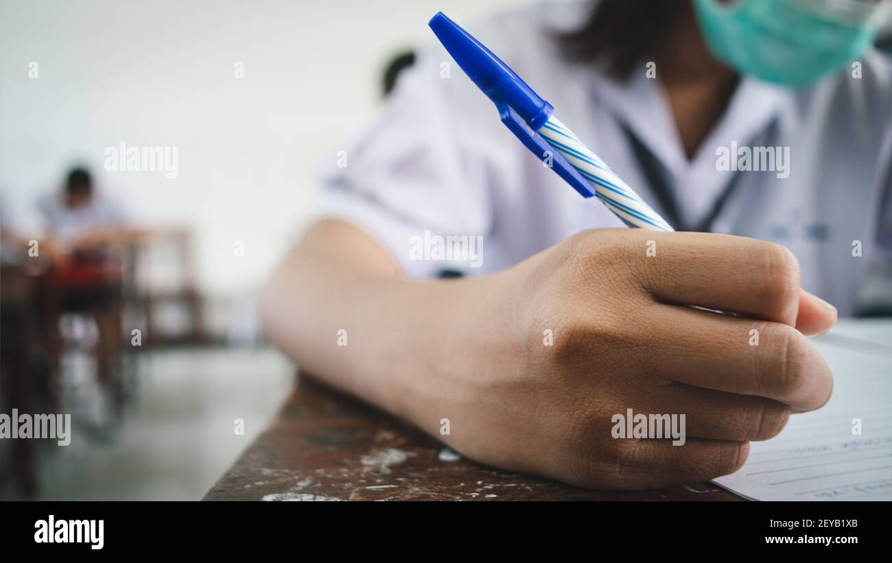 Students writing pen in hand doing exams answer sheets exercises in ...