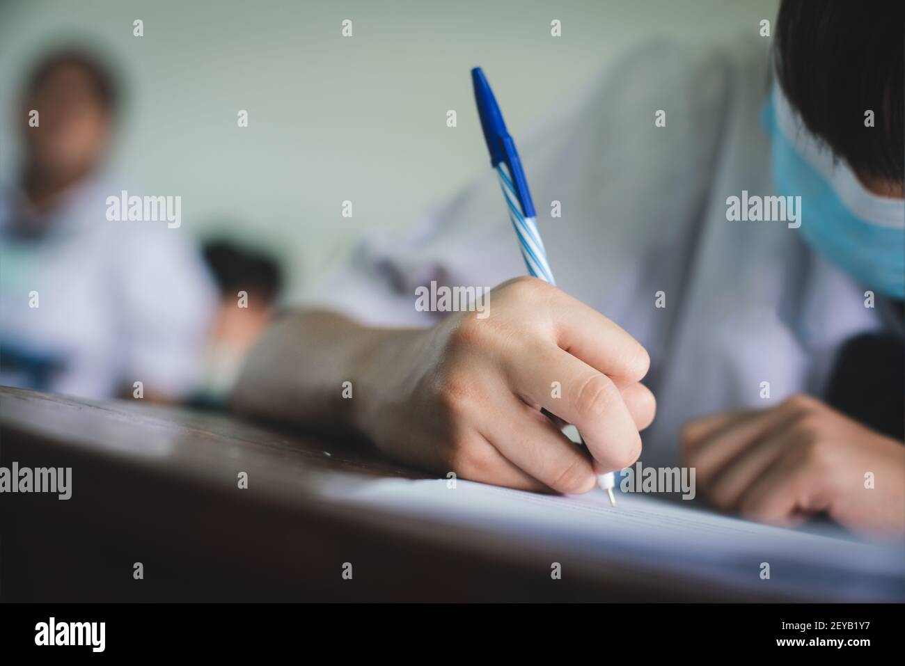 Student writing pen in hand doing exams answer sheets exercises in ...