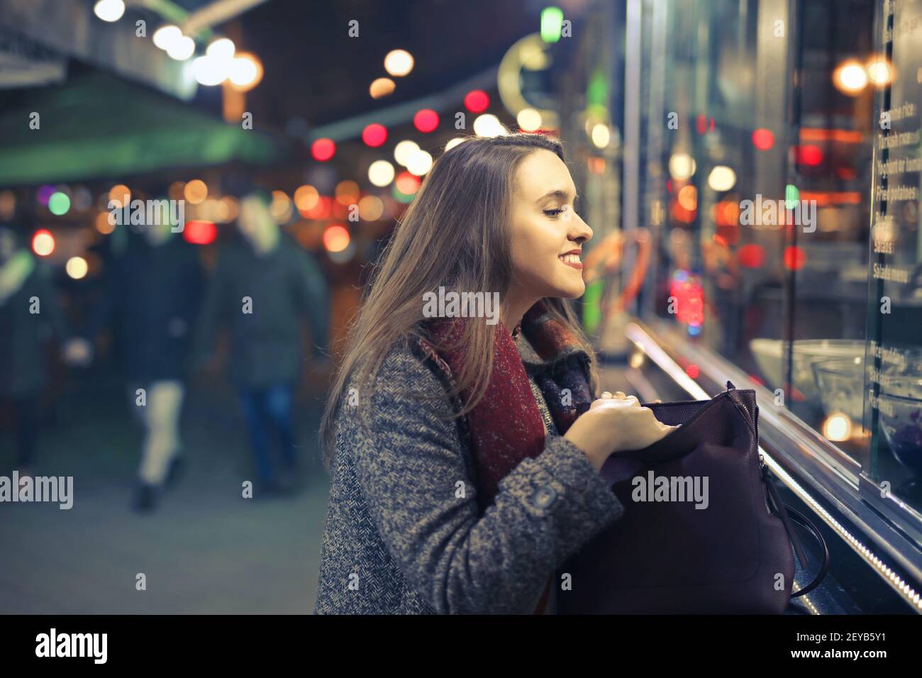A portrait of a European female waiting for a takeaway coffee outdoors ...