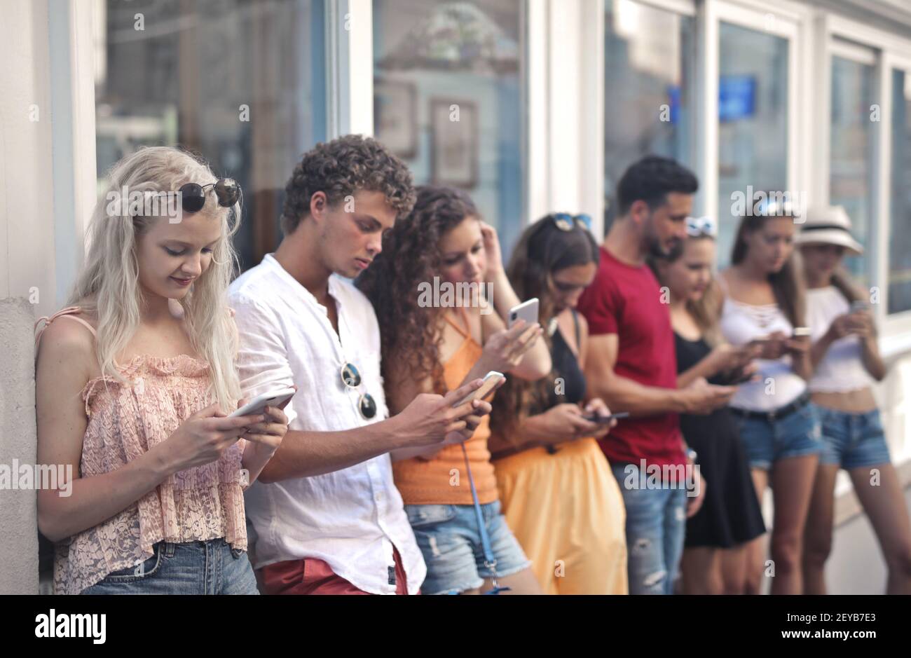 A group of young people using their phones - social media addiction ...