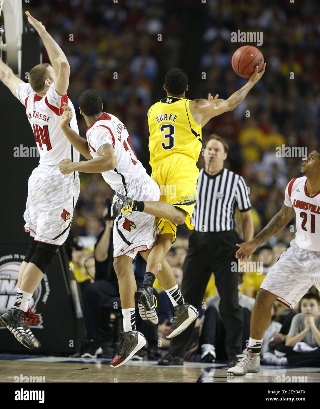 Trey Burke (3) of the Michigan Wolverines puts in a heavily contest ...