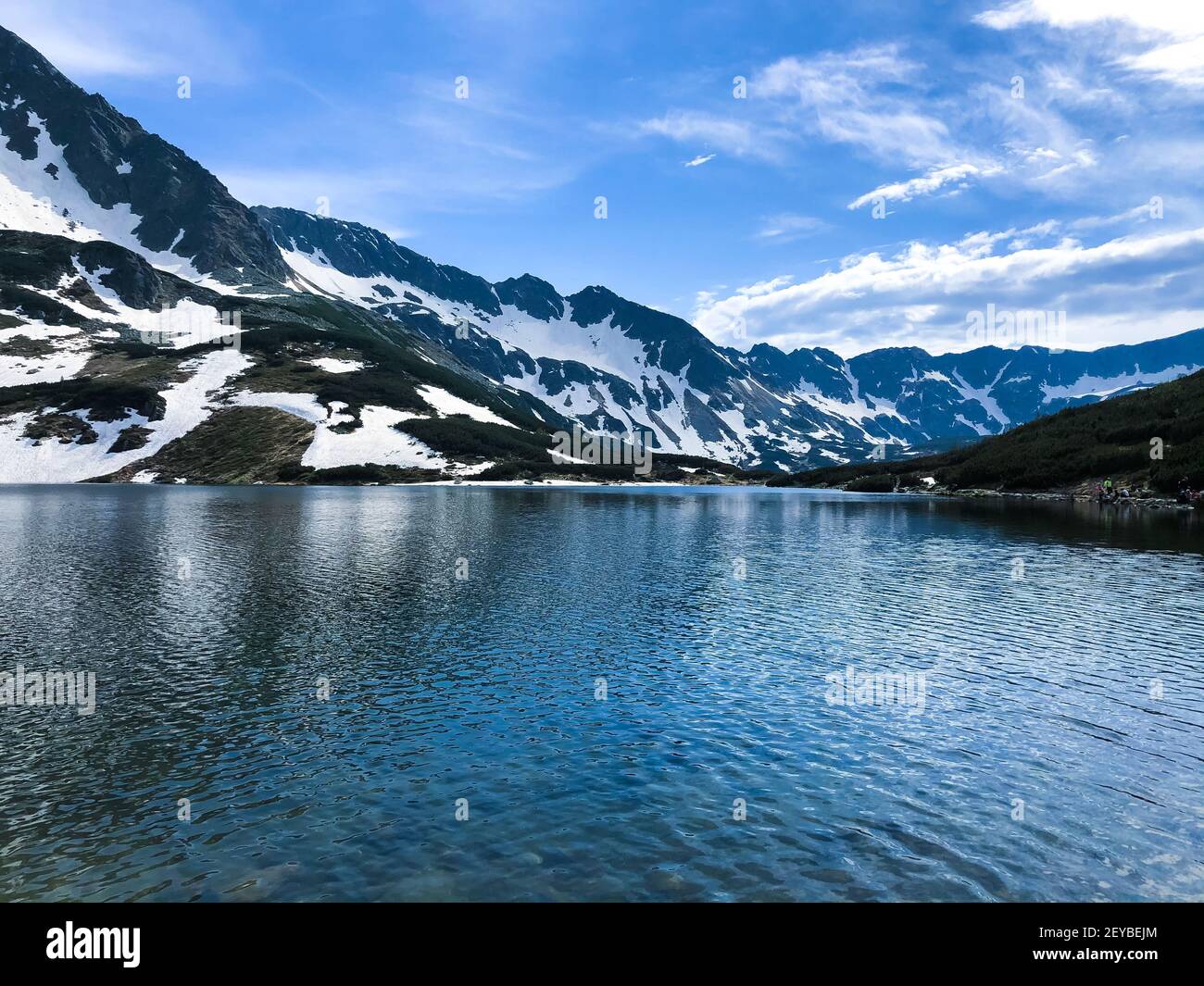 Blue waterscape in the background of snow-covered mountains in the Five ...