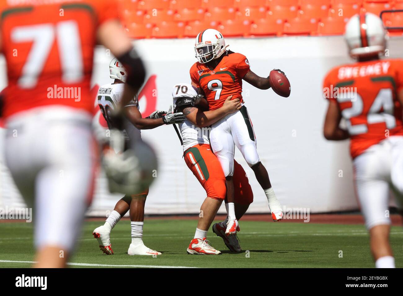 Miami players lift wide receiver Malcolm Lewis in celebration, after ...
