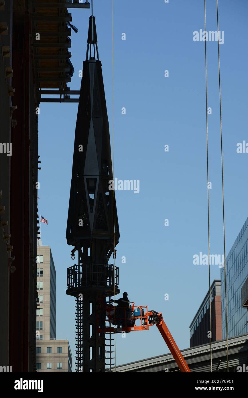 Construction workers prepare the final 408-foot spire section before it ...