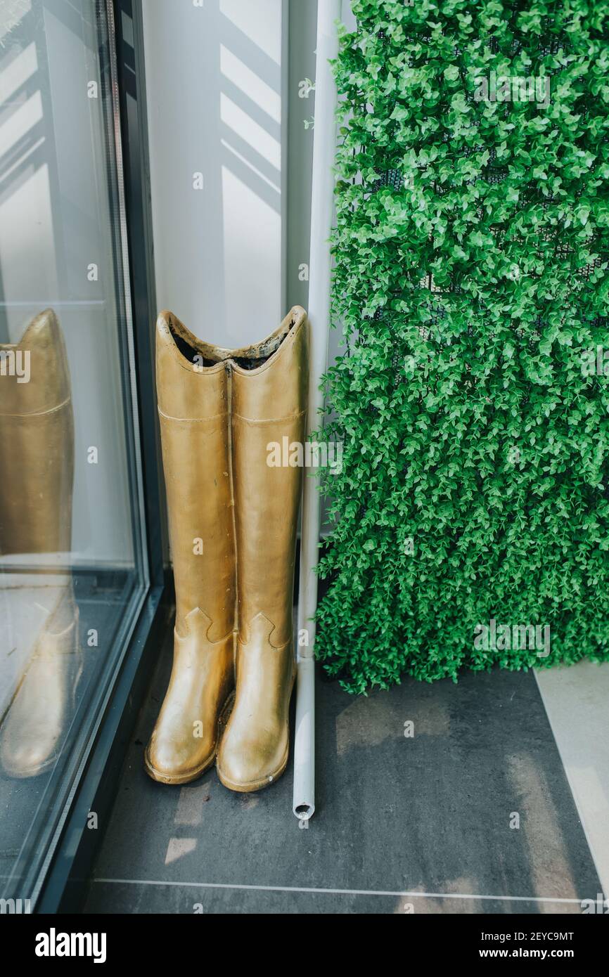 A vertical shot of the golden boots displayed beside the glass window ...