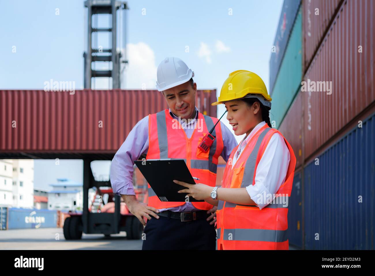 Asian female worker is explaining a check list of container inspections ...