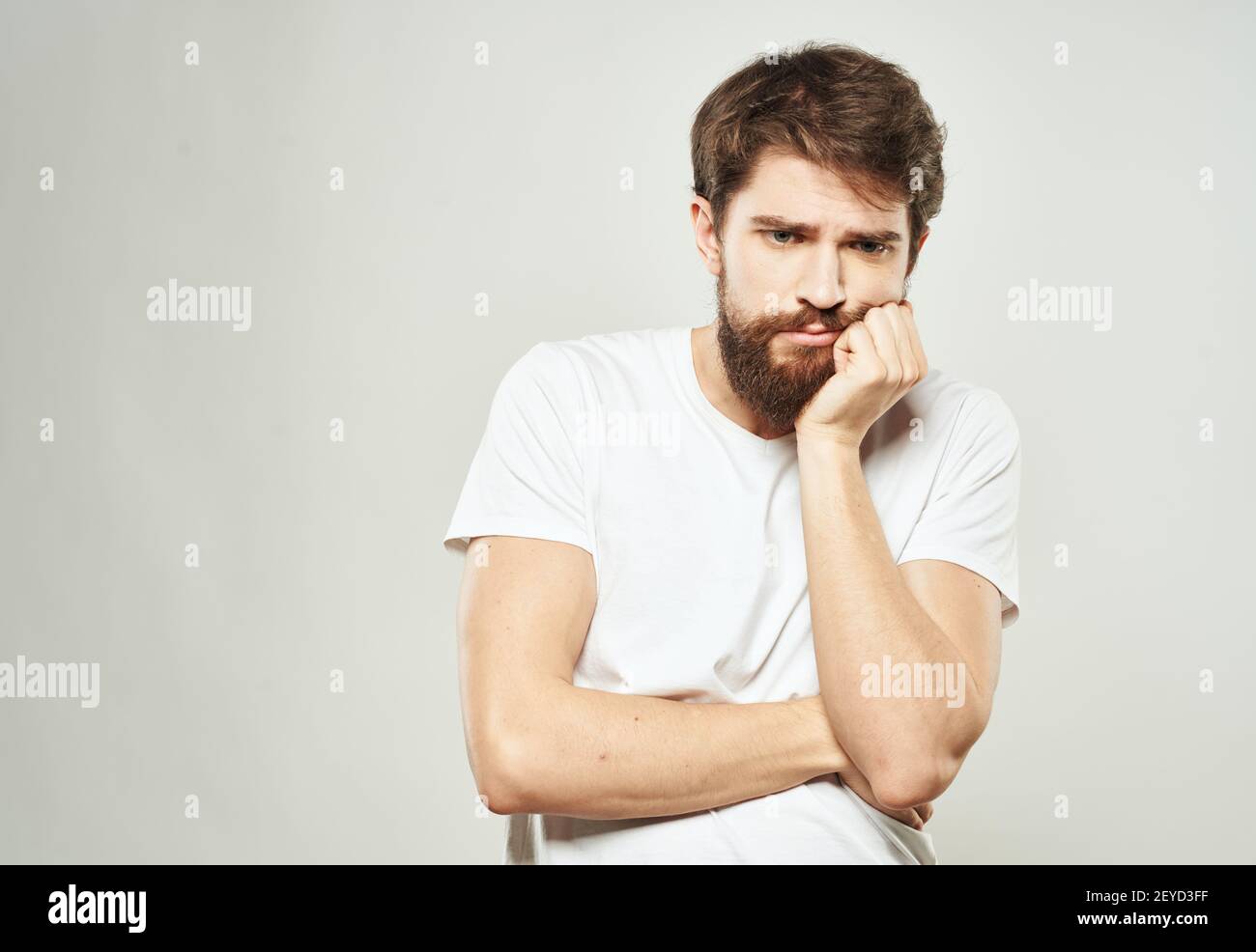 Man touches face with hands emotions model light background Stock Photo ...