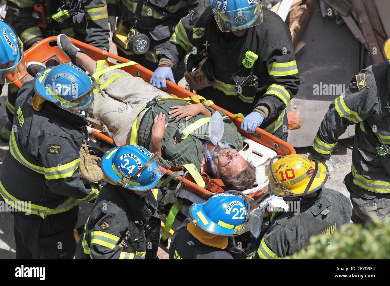 Philadelphia firefighters carry a survivor from the rubble of collapsed ...