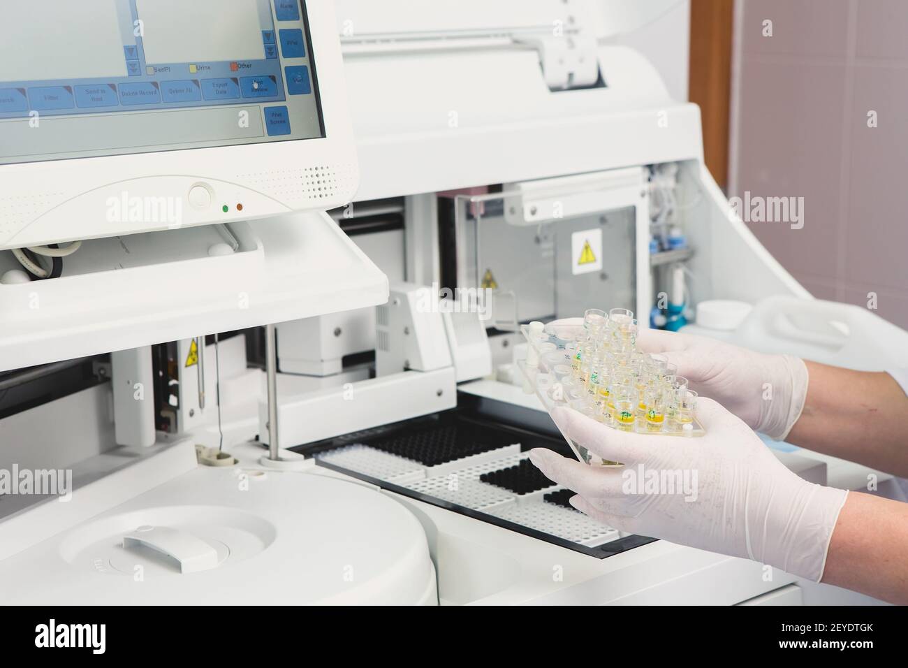 Lab tech loading samples into a chemistry analyzer Stock Photo - Alamy