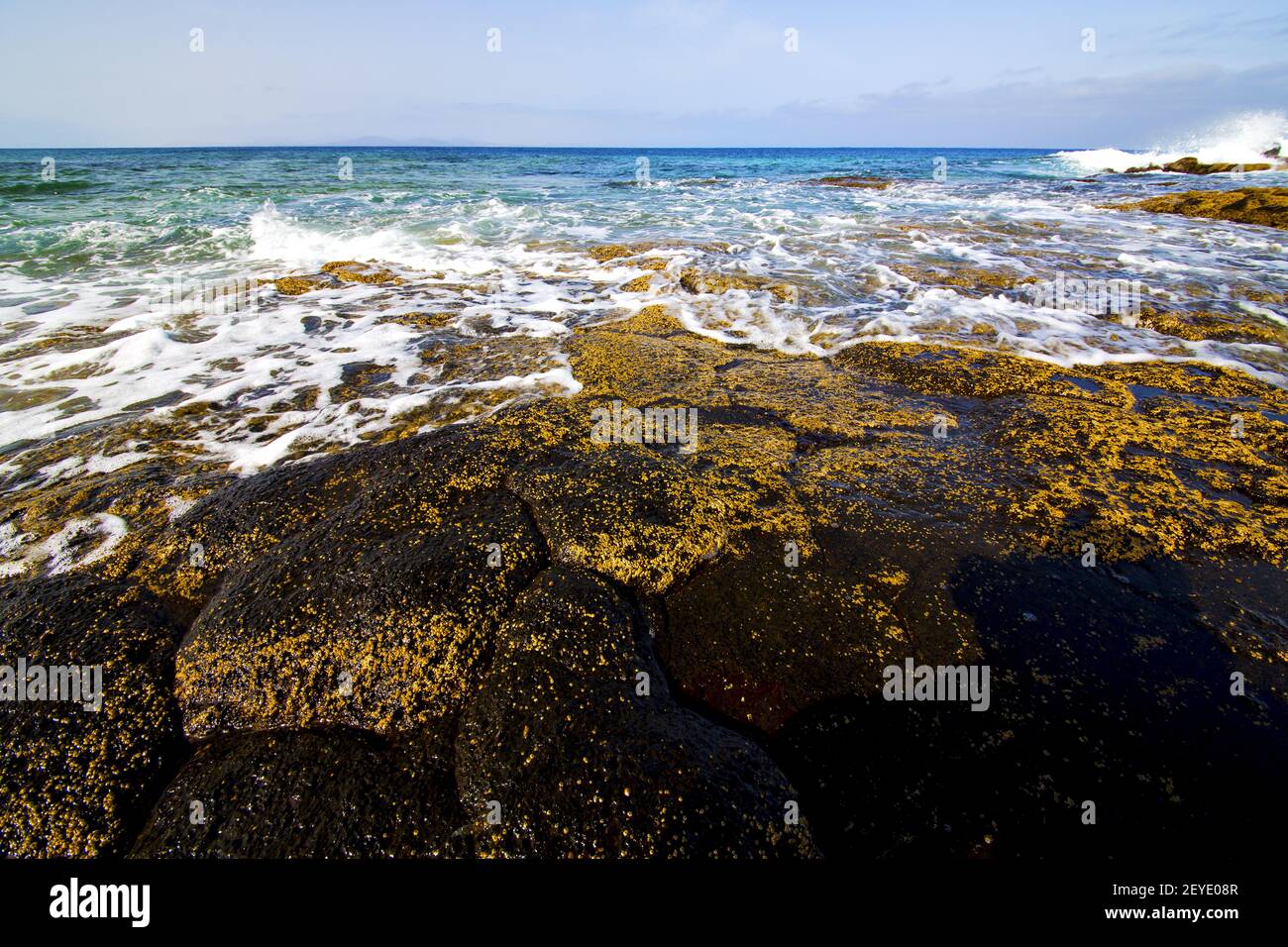 Beach light water foam rock spain sky cloud beach Stock Photo - Alamy