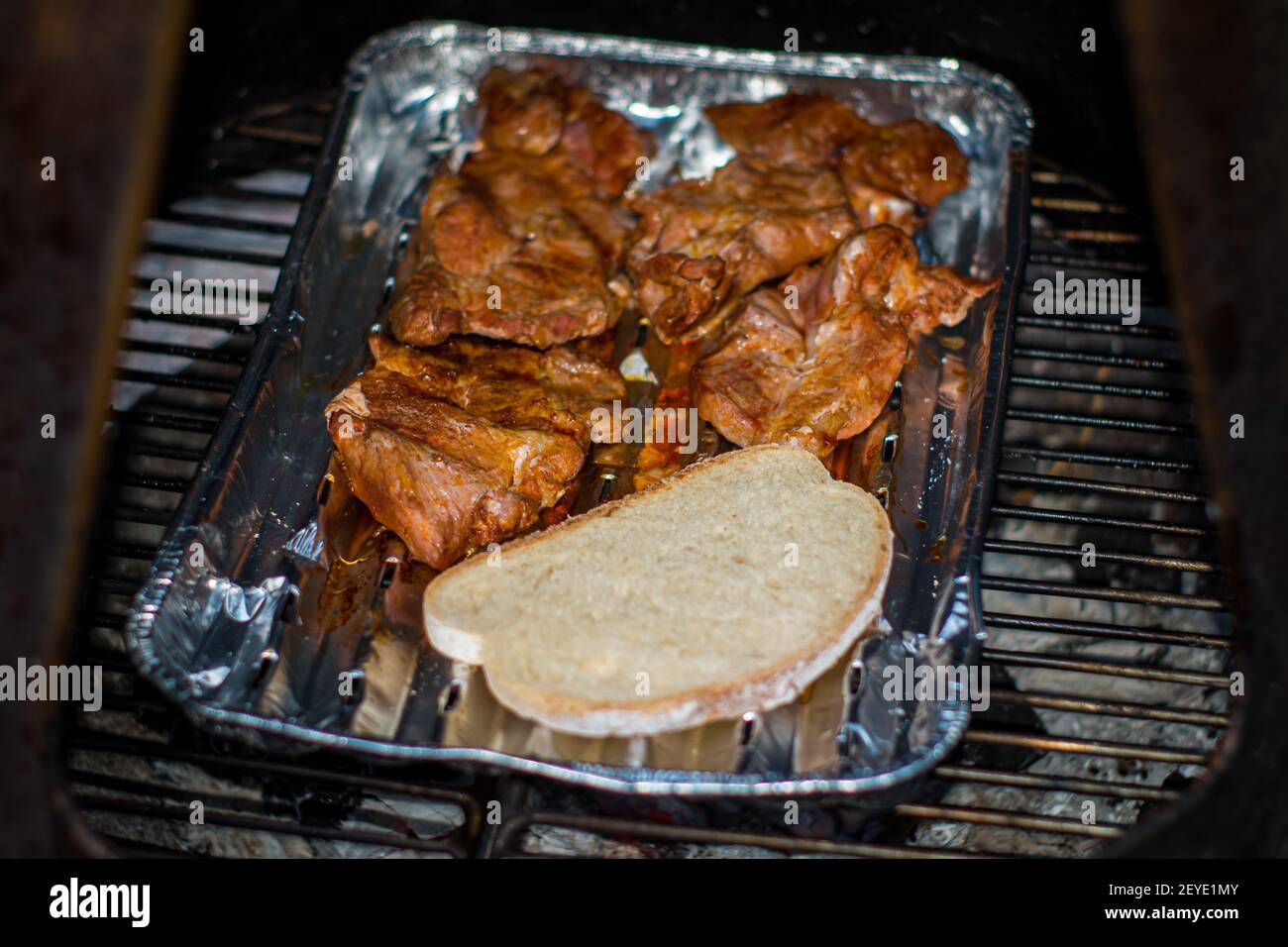 A high angle shot of grilled meat with a bread loaf Stock Photo - Alamy