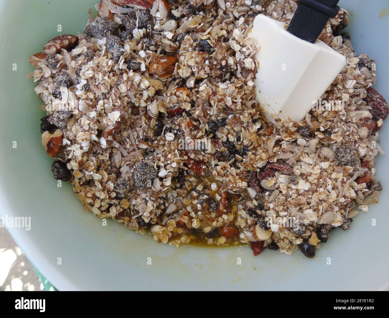 Mix wet ingredients with dry ingredients when making granola. (Photo by ...