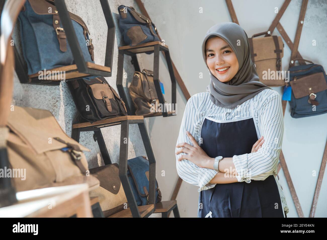 portrait of asian muslim business owner standing in front of his bag ...