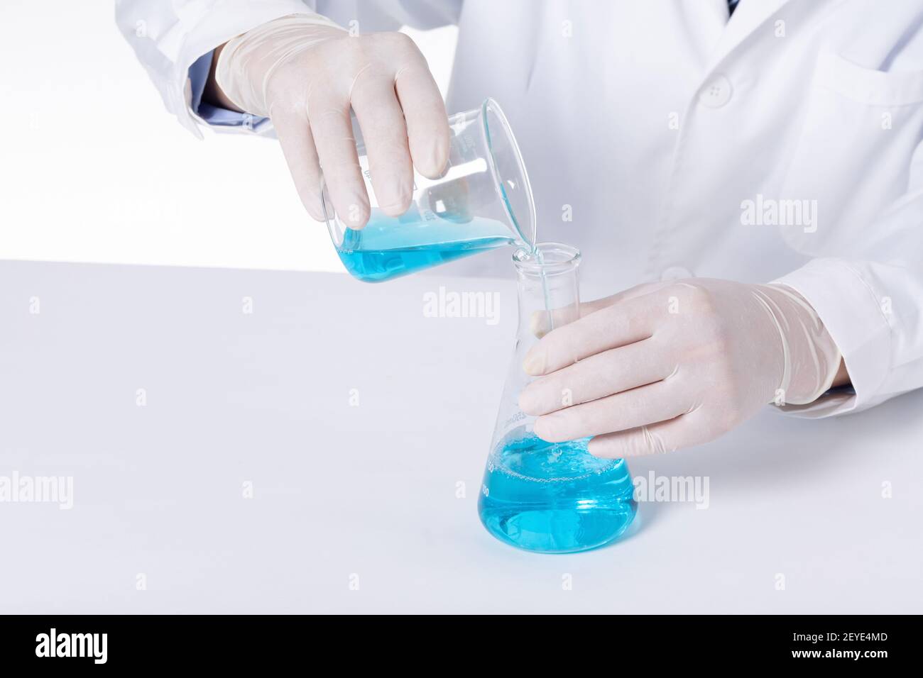A closeup of a scientist experimenting with blue toxic substances in ...