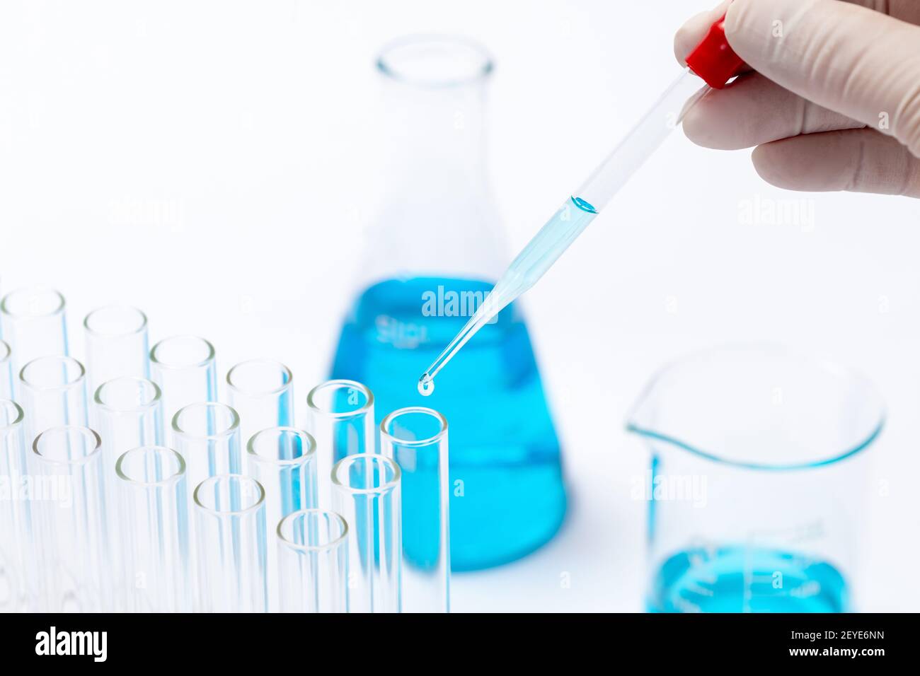 A closeup of a scientist experimenting with blue toxic substances in a ...