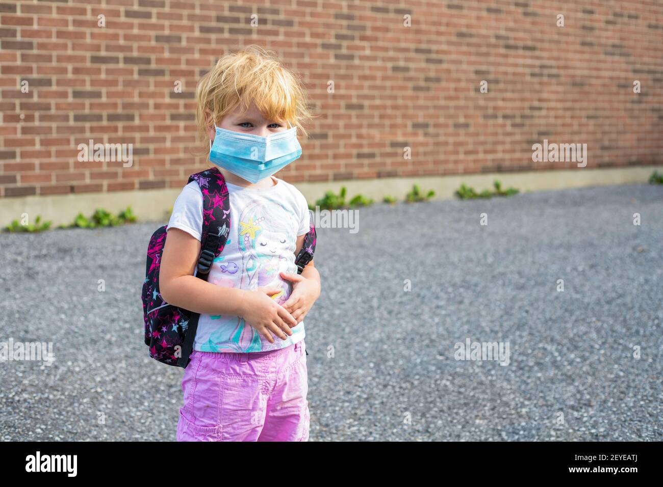 Little preschooler child in mask with backpack during corona virus near ...