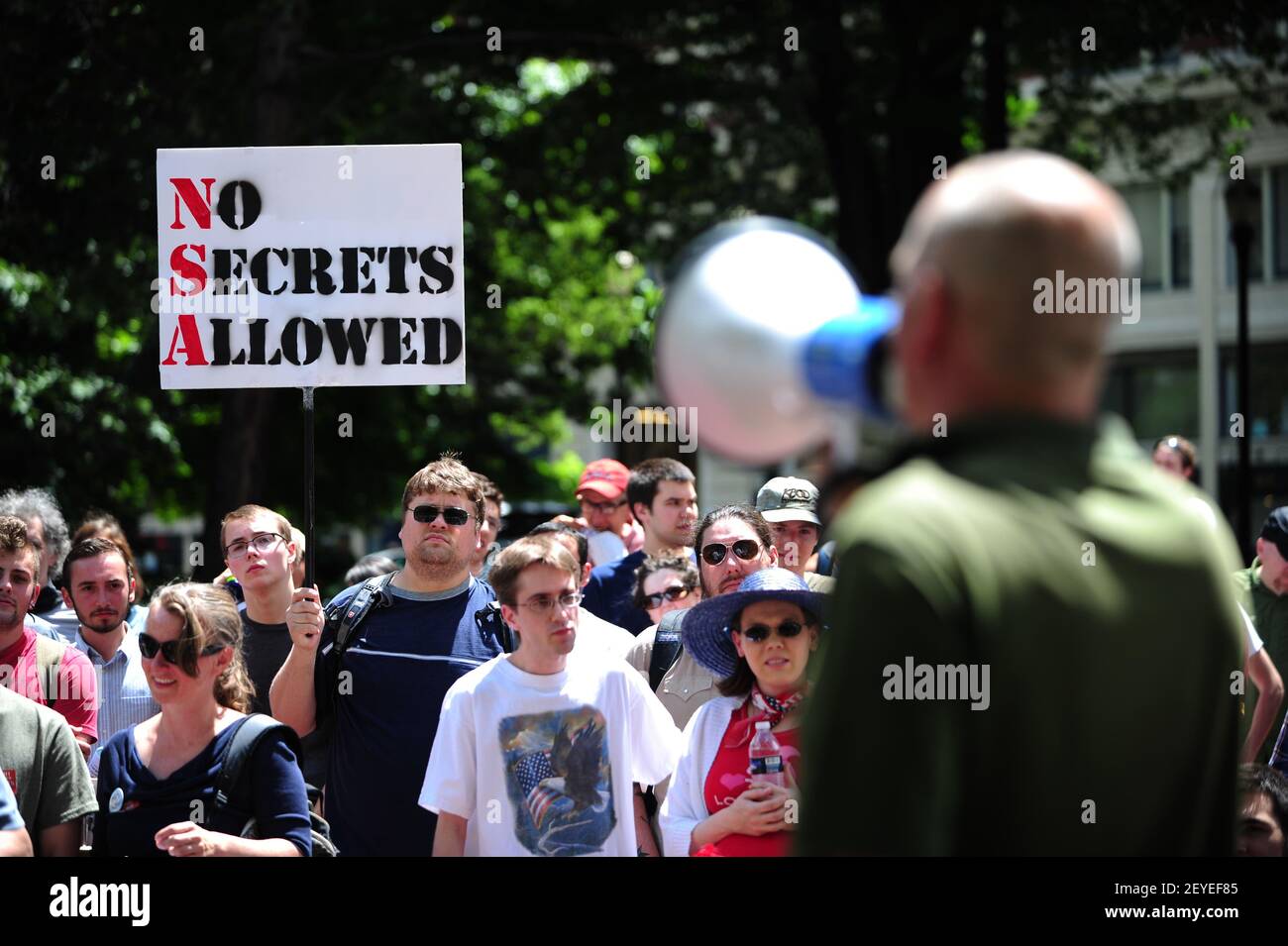 A protester holds an NSA (No Secrets Allowed) sign a t a protest ...