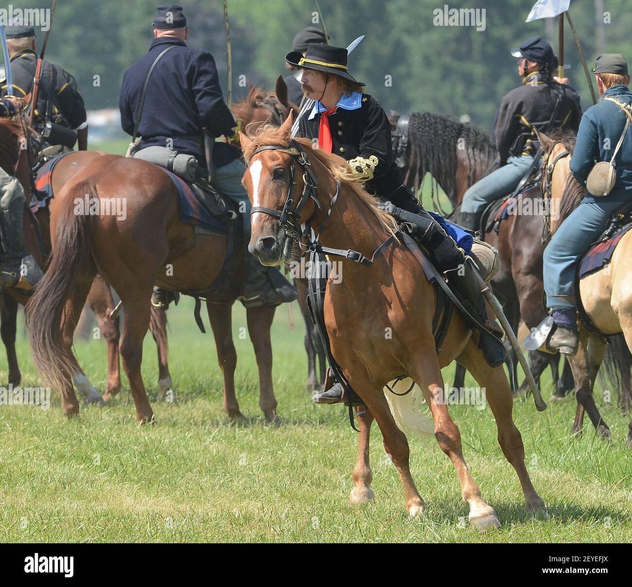 A Union re-enactor portraying Gen. George Custer, right, takes part in ...