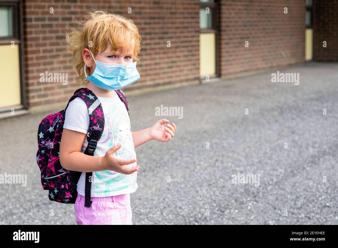 Little preschooler child in mask with backpack during corona virus near ...