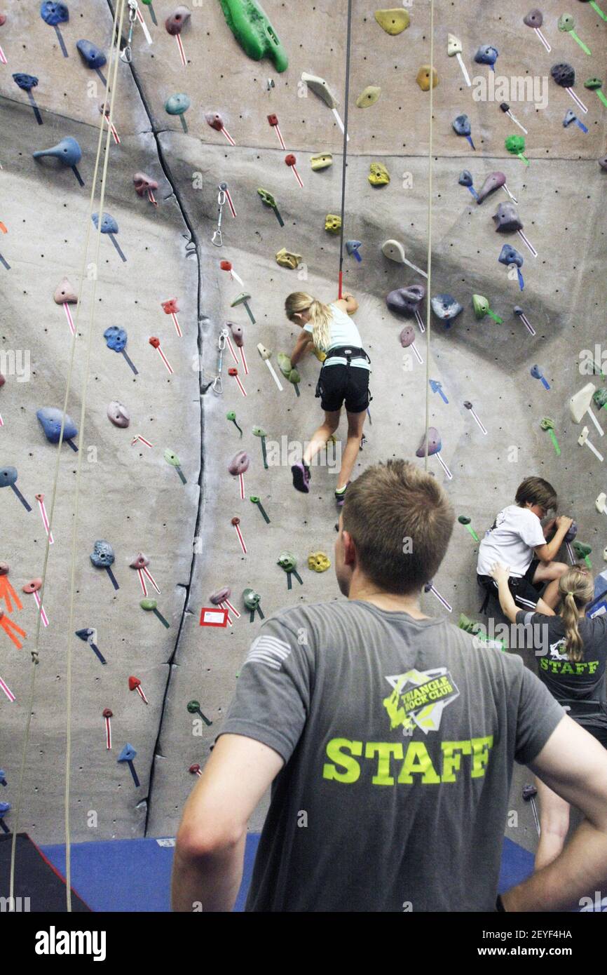A Triangle Rock Club instructor watches as local children work on their ...