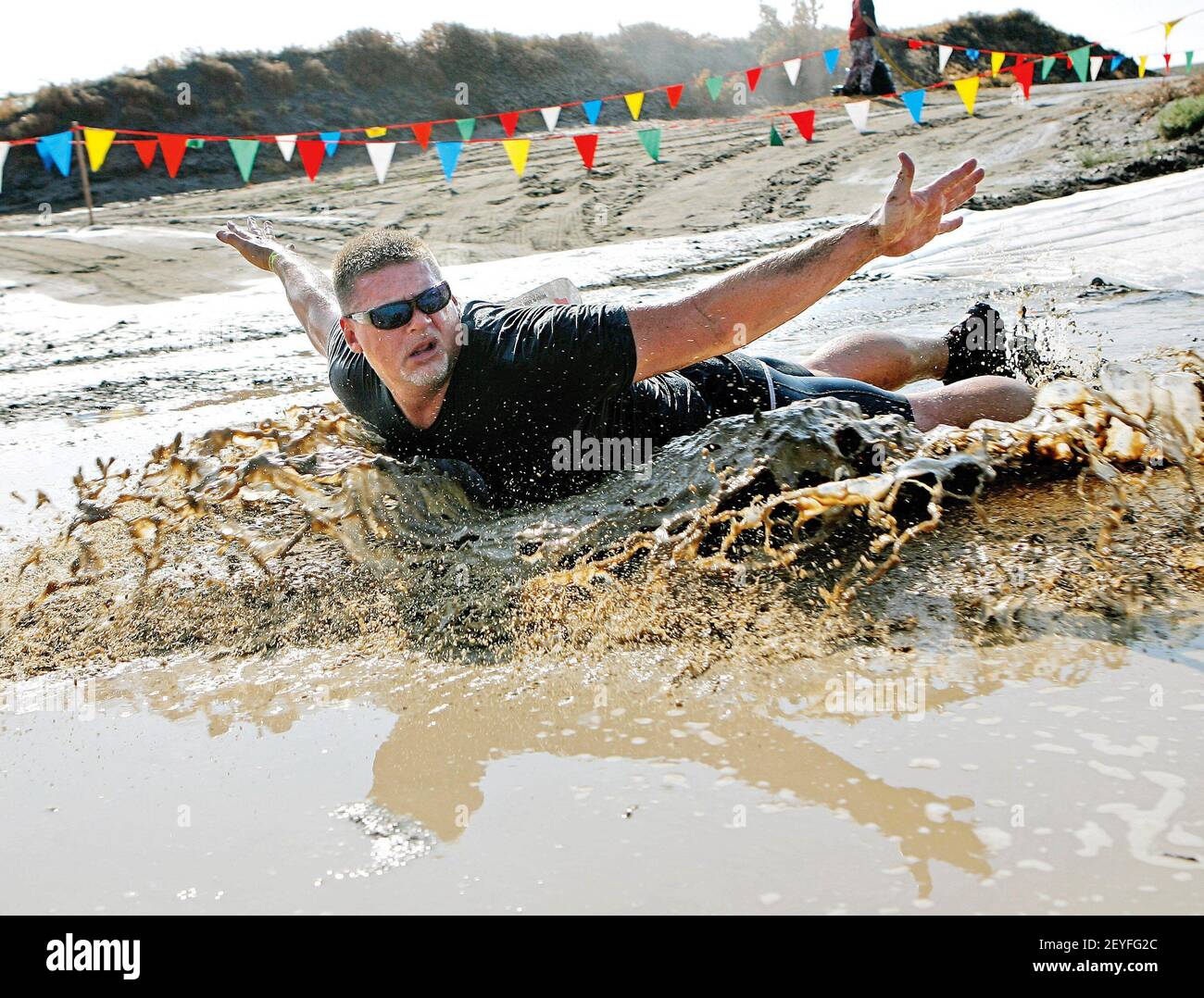 Paul Singer slides through the mud while joining about 350 others in ...