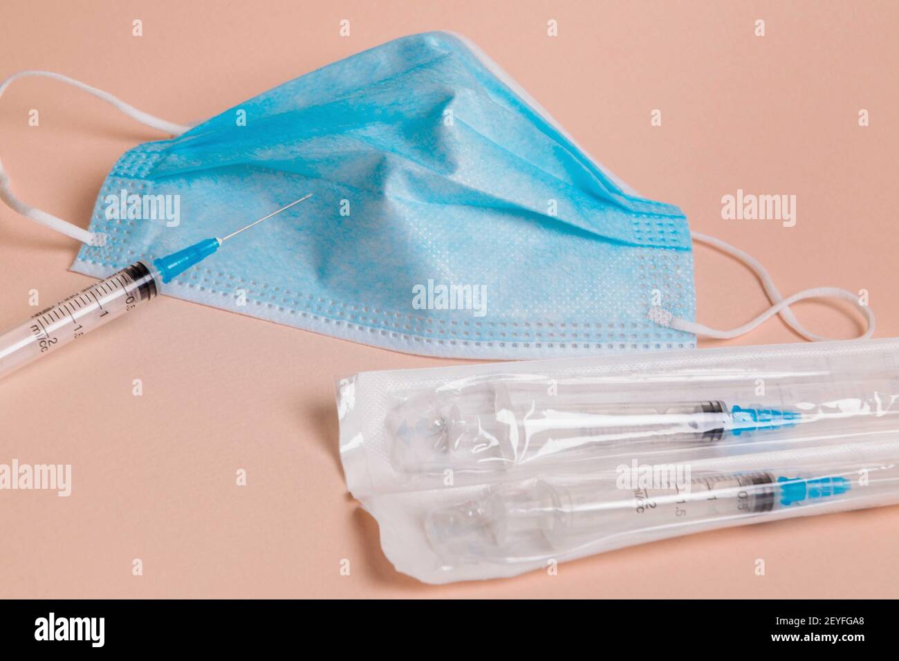 On the table is a medical mask with a syringe and medicine for ...
