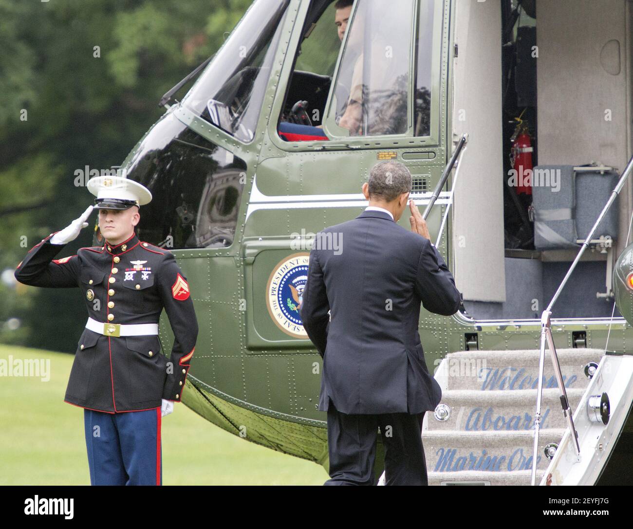 United States President Barack Obama salutes the Marine Guard as he ...