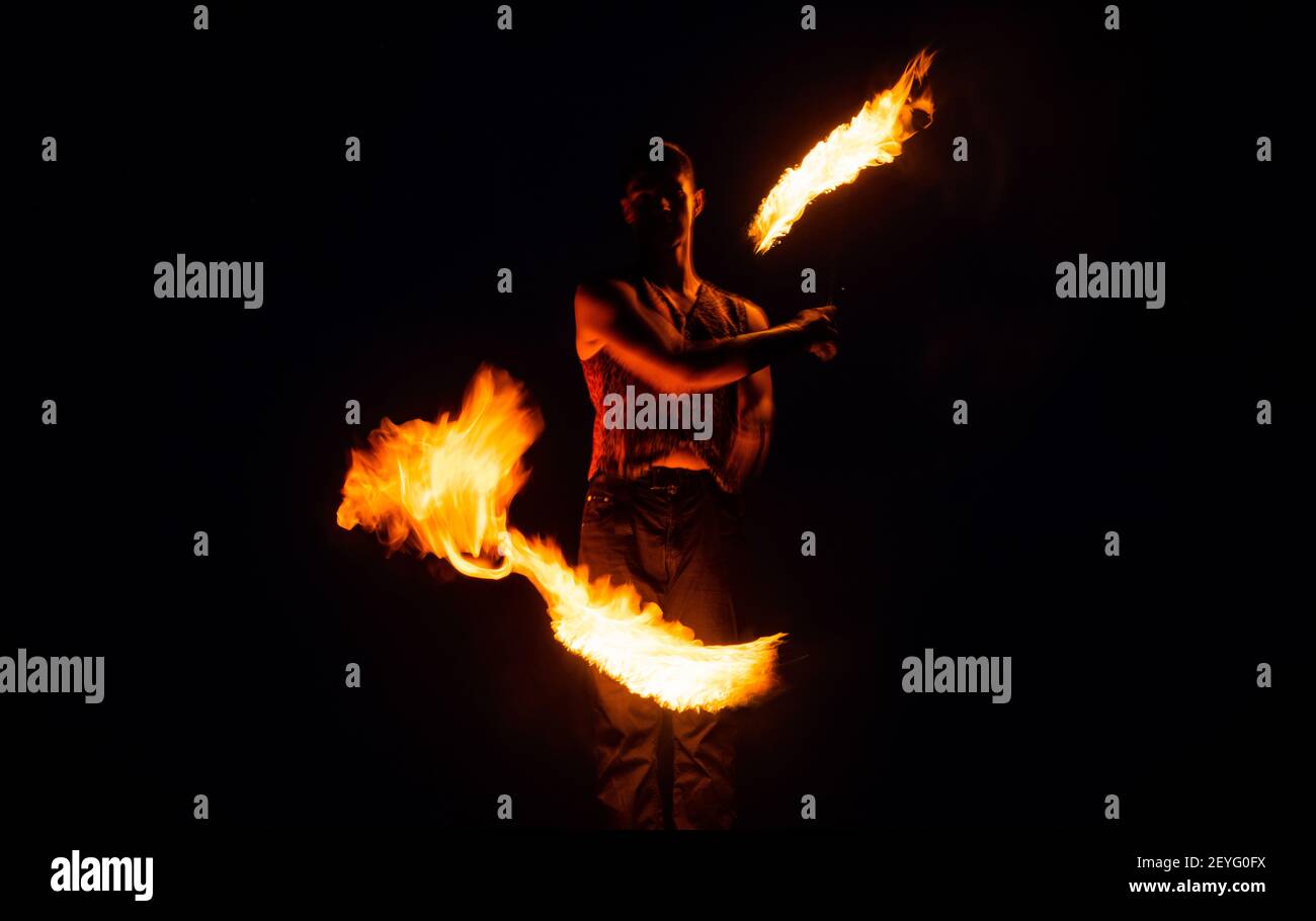 Fakir show. Happy man manipulate with burning poi. Fire fakir perform ...