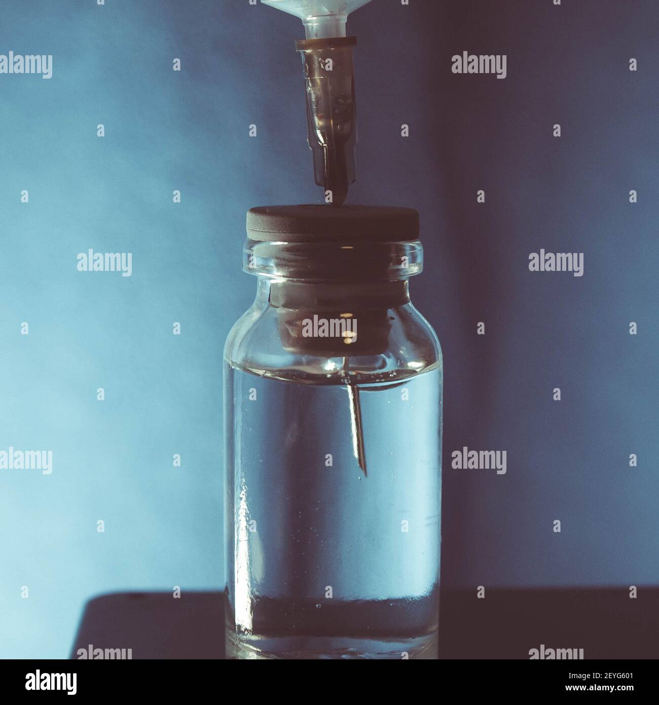 Vaccine in vitro. Medicine in a flask on a blue background. Antibiotic ...