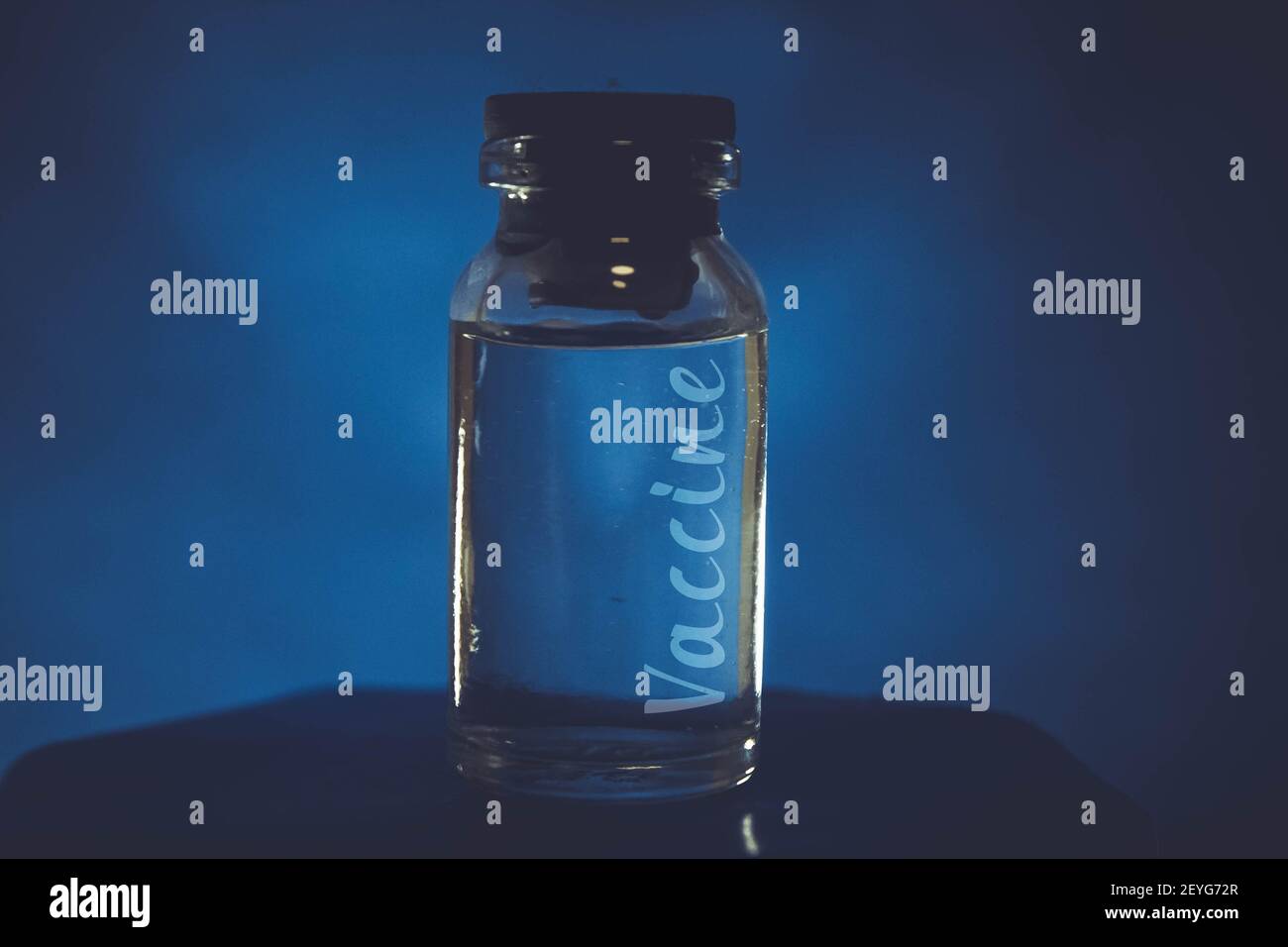 Vaccine in vitro. Medicine in a flask on a blue background. Antibiotic ...
