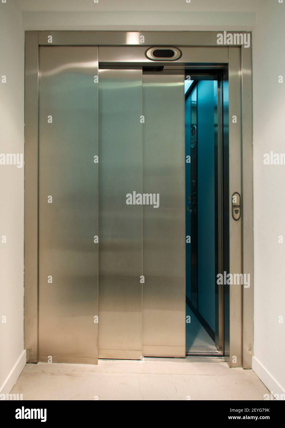 Modern elevator doors open to a brightly lit corridor in a contemporary building Stock Photo - Alamy