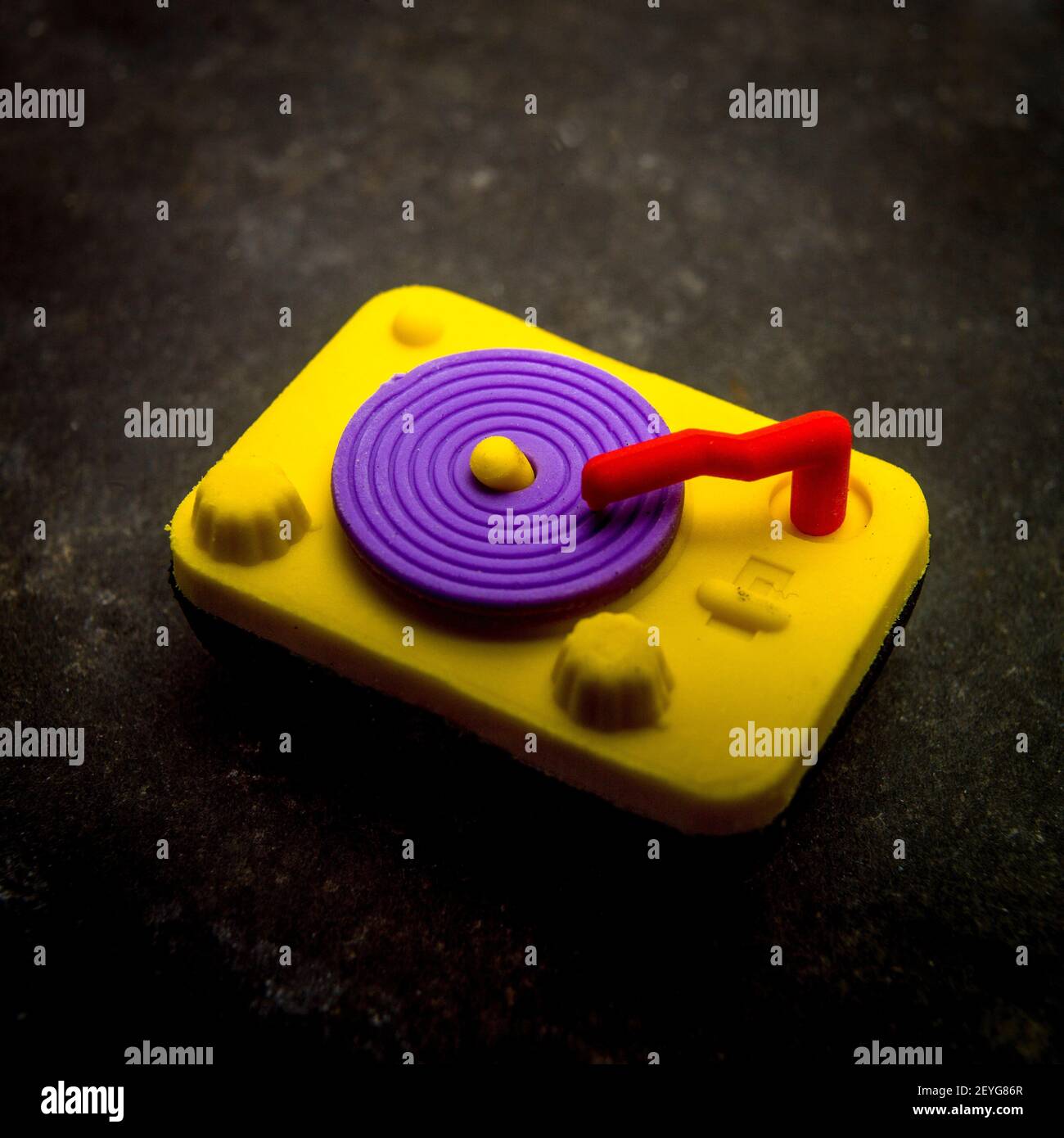 Colorful toy record player with purple turntable and red arm capturing ...