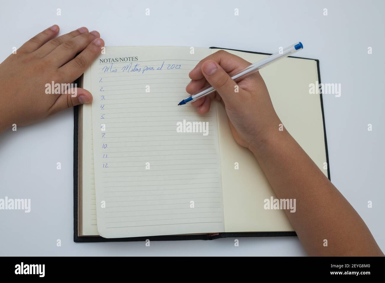 A top view of little boy hands writing down notes in his notebook Stock ...