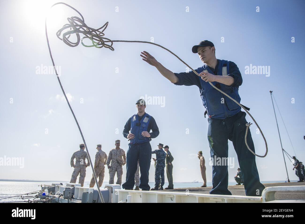 U.S. Navy Seaman Dustin Johnson, right, throws a messenger line to the ...