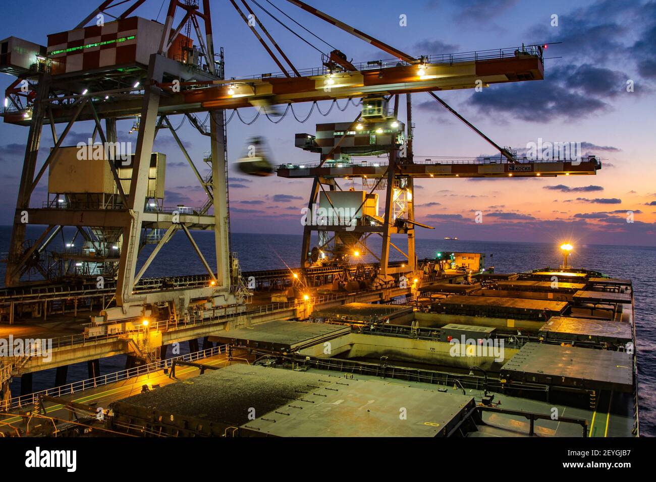 Port Cranes are unloading coal from Ship at night Stock Photo - Alamy