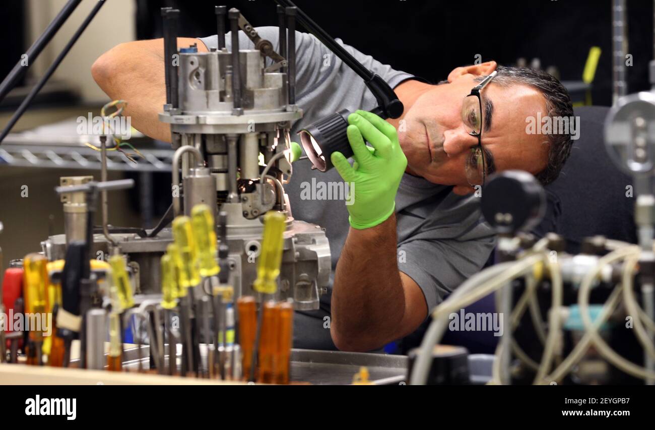 Woodward Inc. assembly technician Chuck Merritt shines a light on a new ...