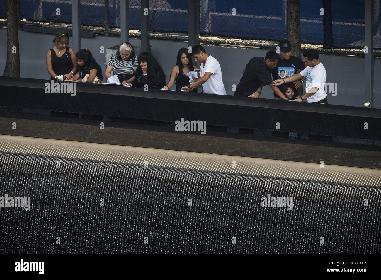 People gather around the North Tower pool during memorial ceremonies ...