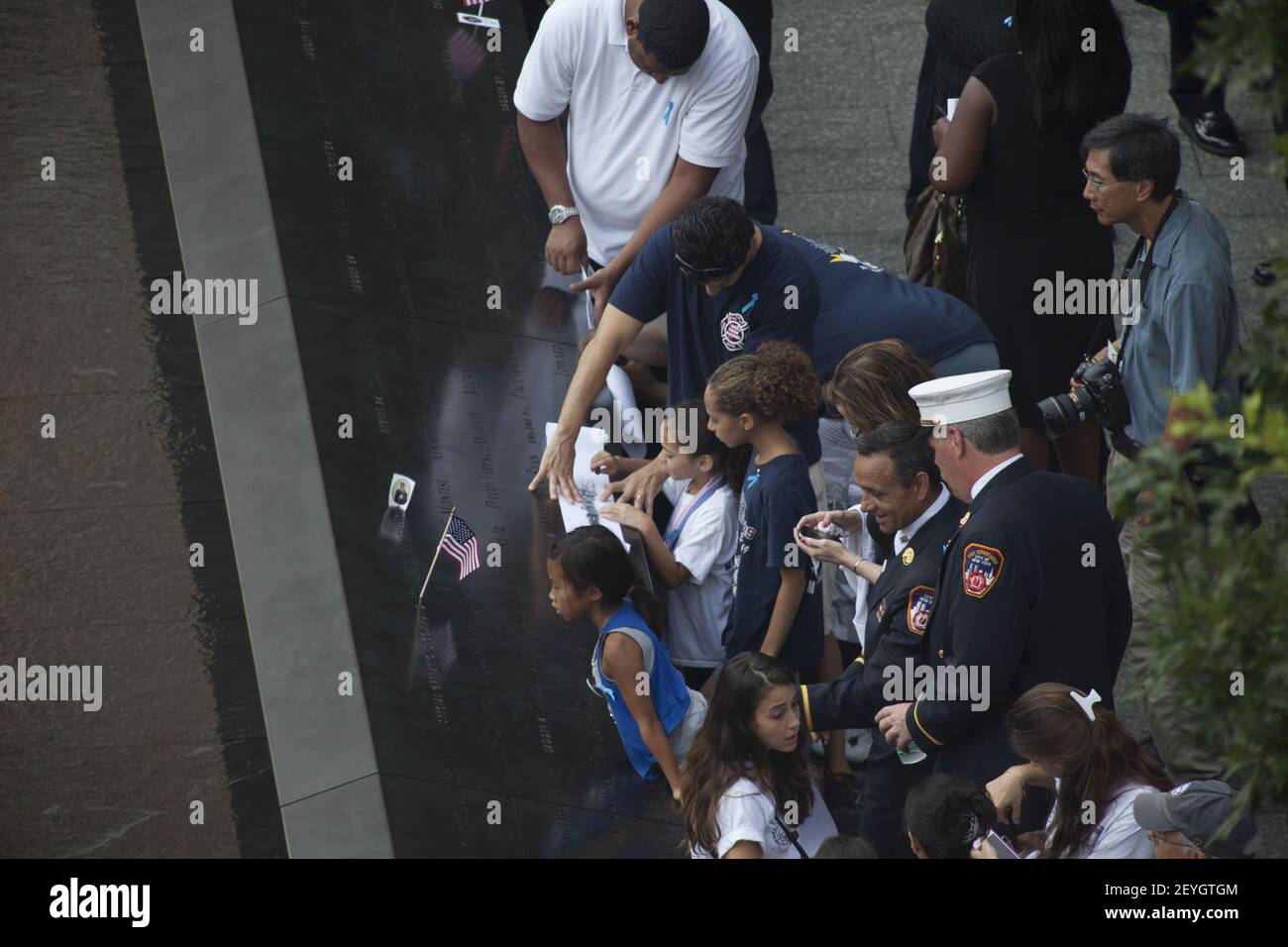 Victims family members mourn at the names plaques at the 9/11 Memorial ...