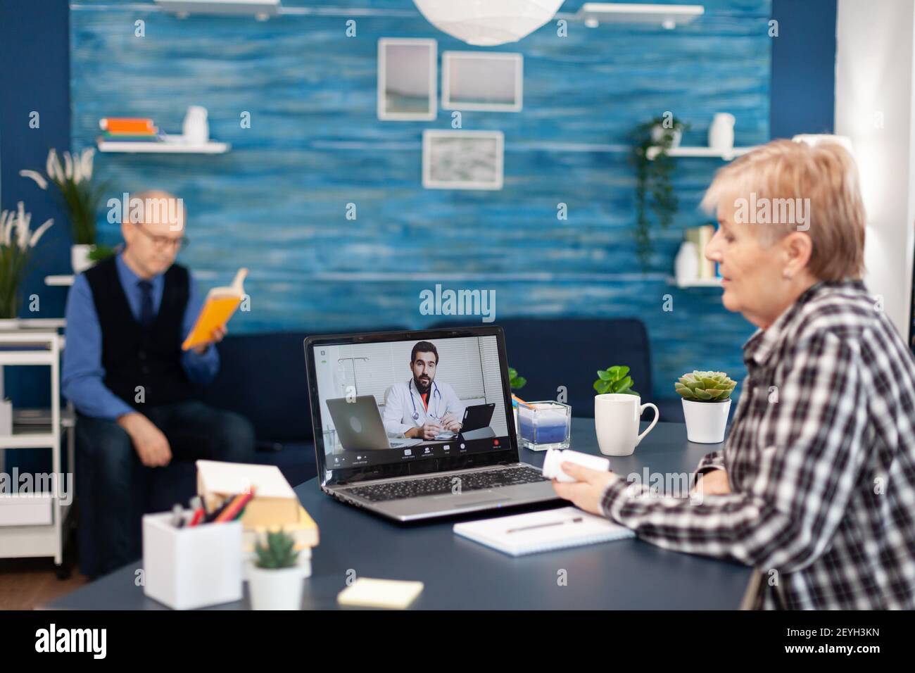Young doctor talking with senior patient during facetime consultation ...