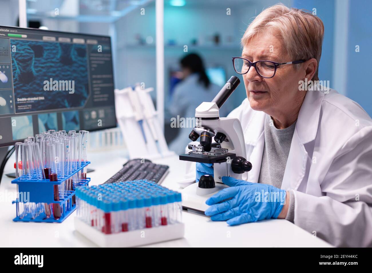 Pharmacy senior scientist working with professional microscope in ...