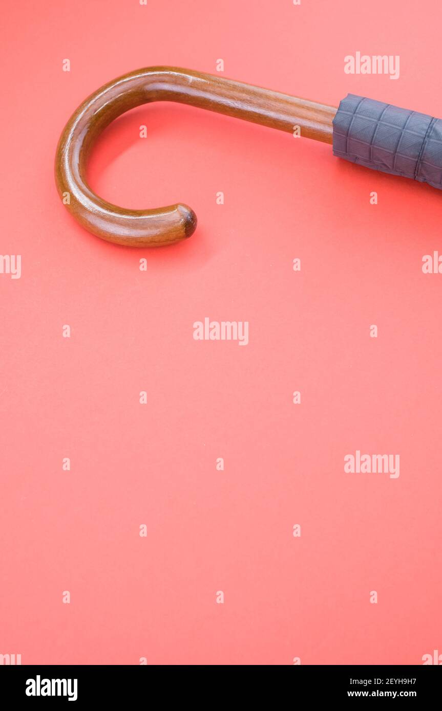 A vertical shot of a hooked umbrella handle on a red background Stock ...