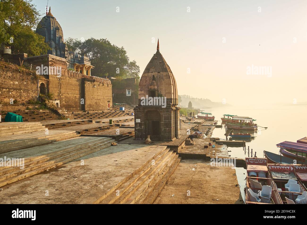 Boats await tourists at Maheshwar Ghats next to Shiv Temple Stock Photo ...