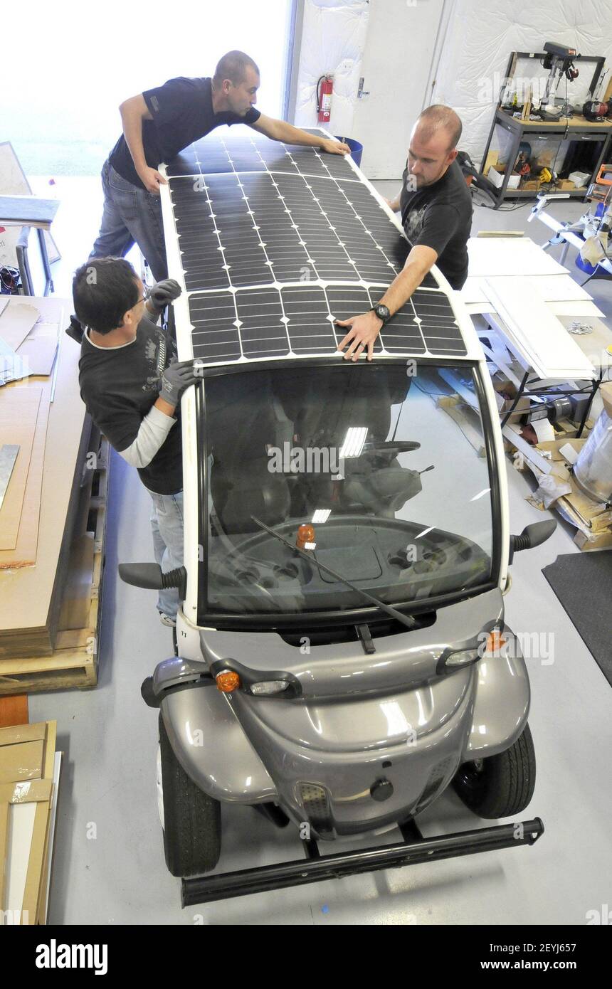 Bob O'Quinn, from left, Marty Mullis and Alan Galyan install a solar ...