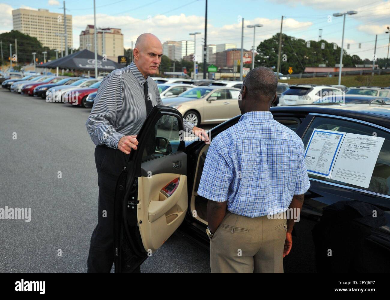 Lexus salesman Randy Autrey, left, shows Raymone Sleurancois a car at a ...