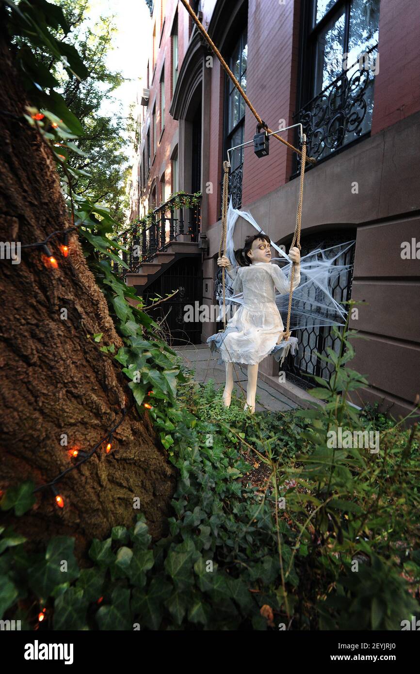 A life-size child mannequin on a swing, spider webs, skulls and bones ...